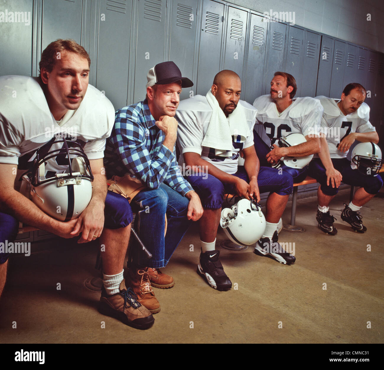 Industrial construction worker in gym locker room with football players ...
