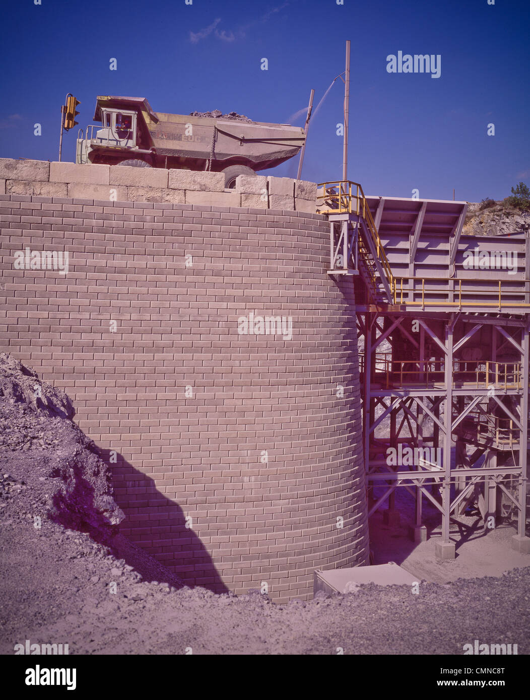 Large truck, Cinder block wall in stone quarry Stock Photo - Alamy