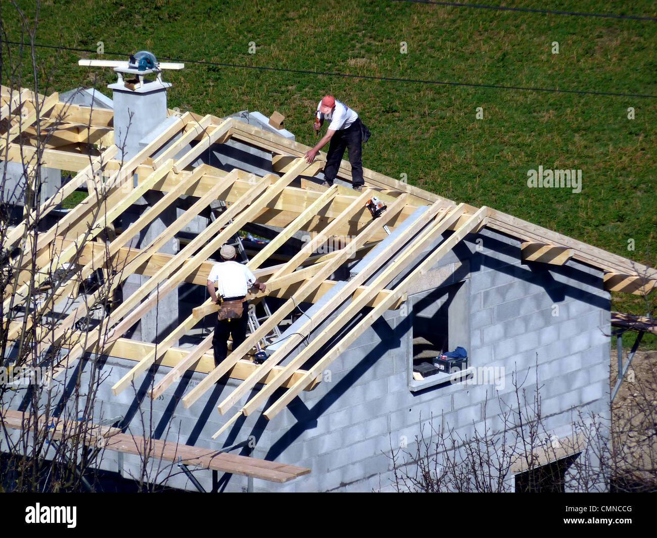 Carpenter building a roof of a house at a construction site Stock Photo ...