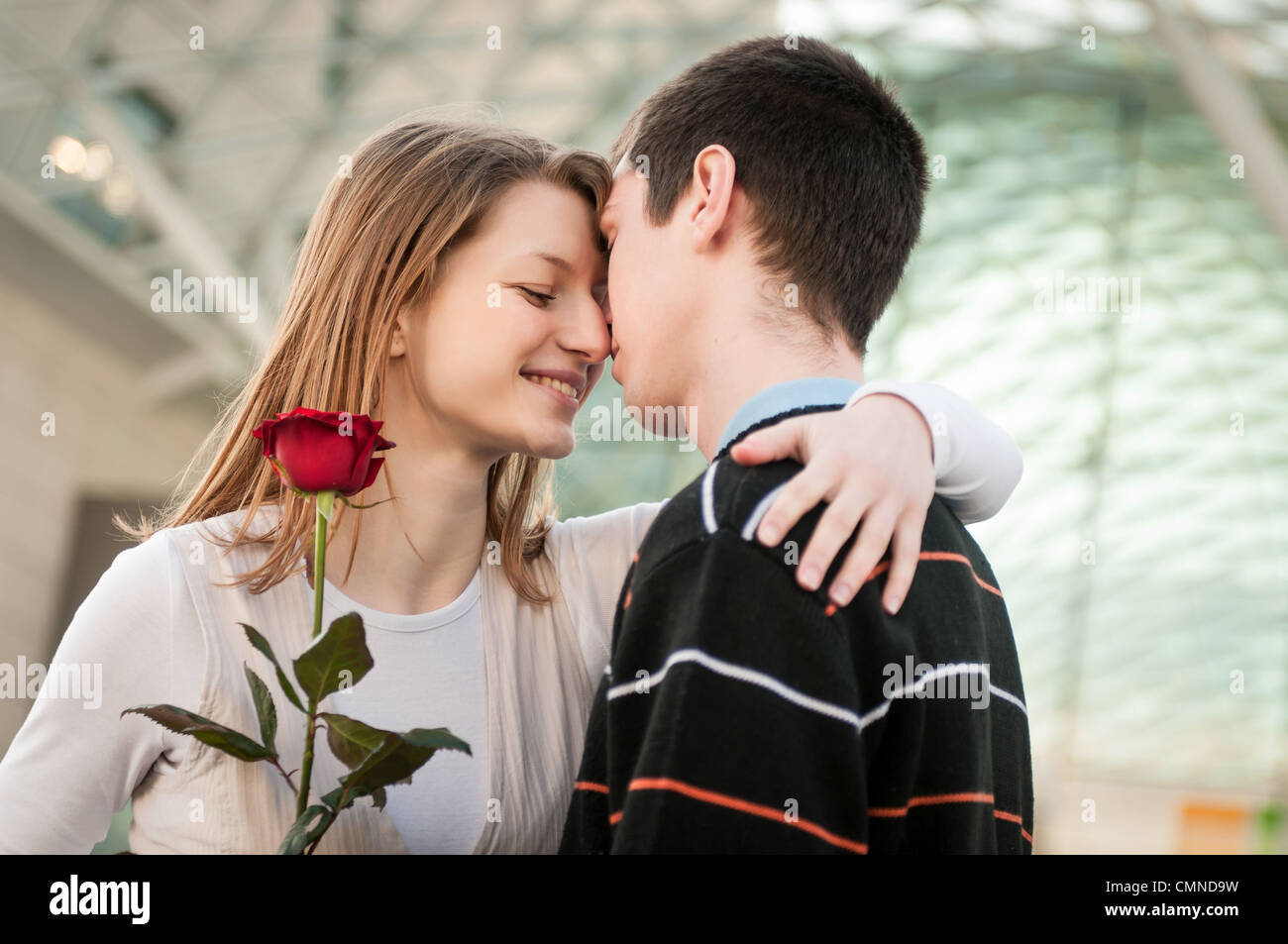Young man handing over a flower (red rose) to woman - outdoor lifestyle ...