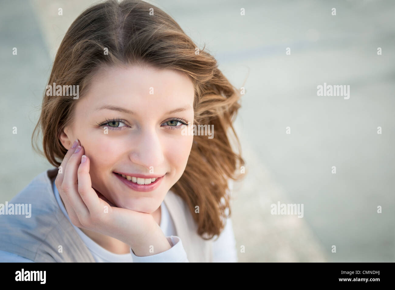 Portrait of young smiling woman - grey background Stock Photo - Alamy