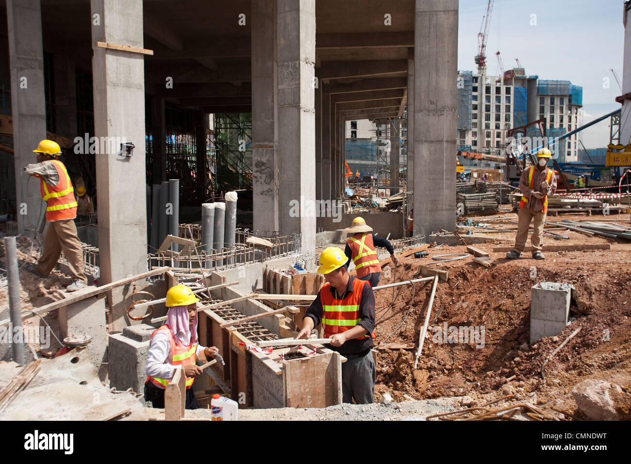 Migrant workers from around Asia work on the construction site of ...