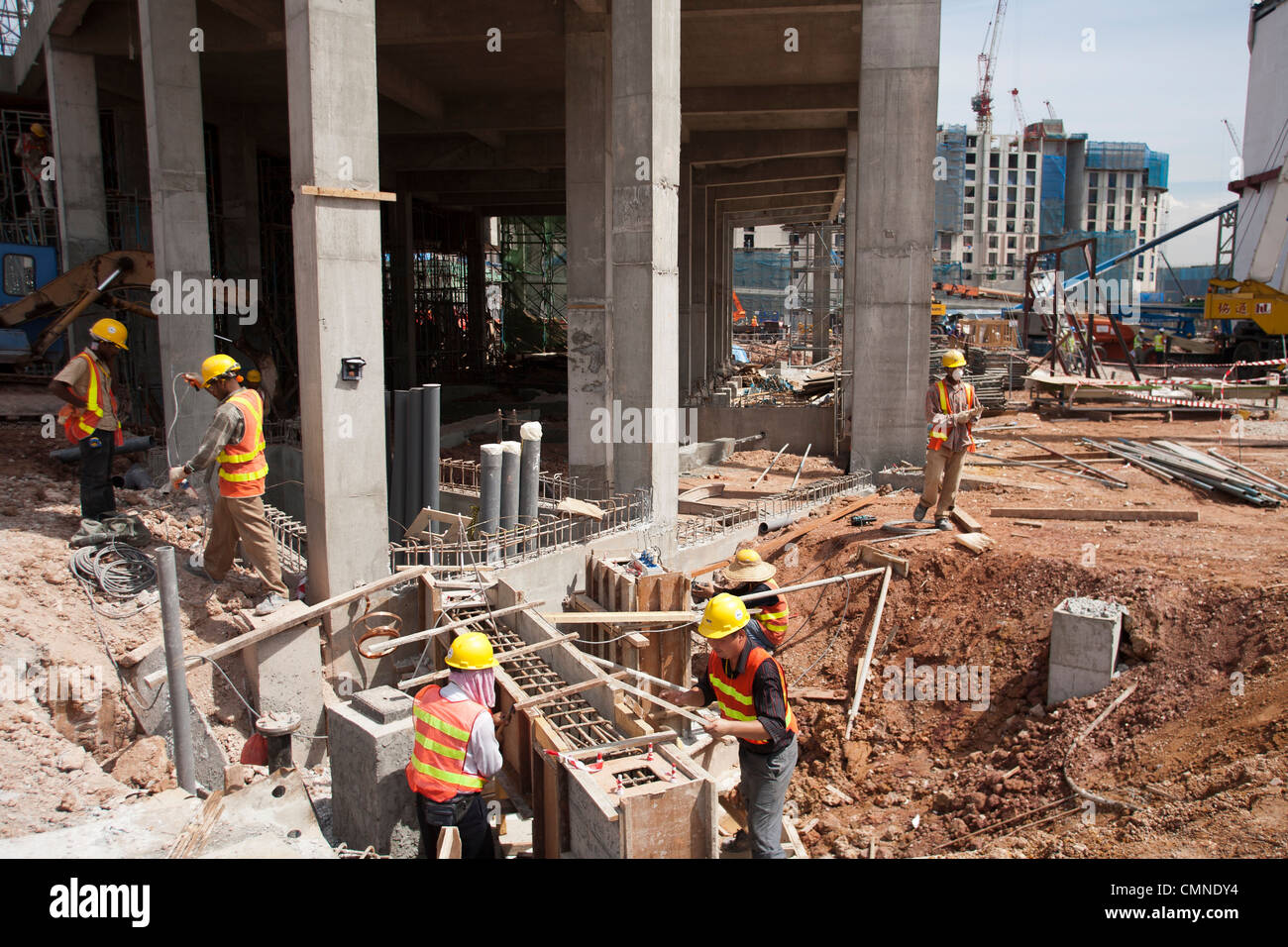 Migrant workers from around Asia work on the construction site of ...