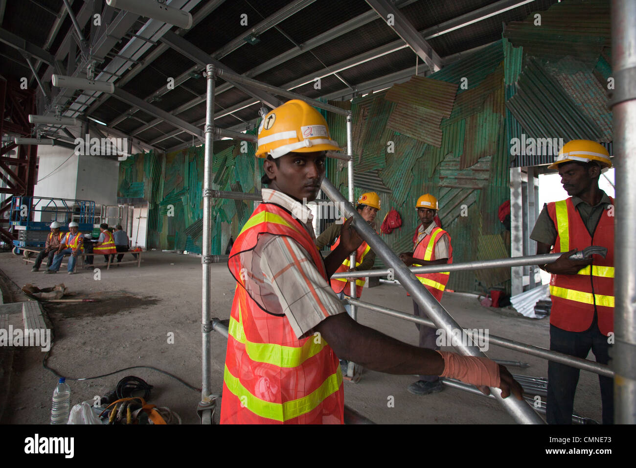 Migrant workers from South Asia work on the construction site of ...