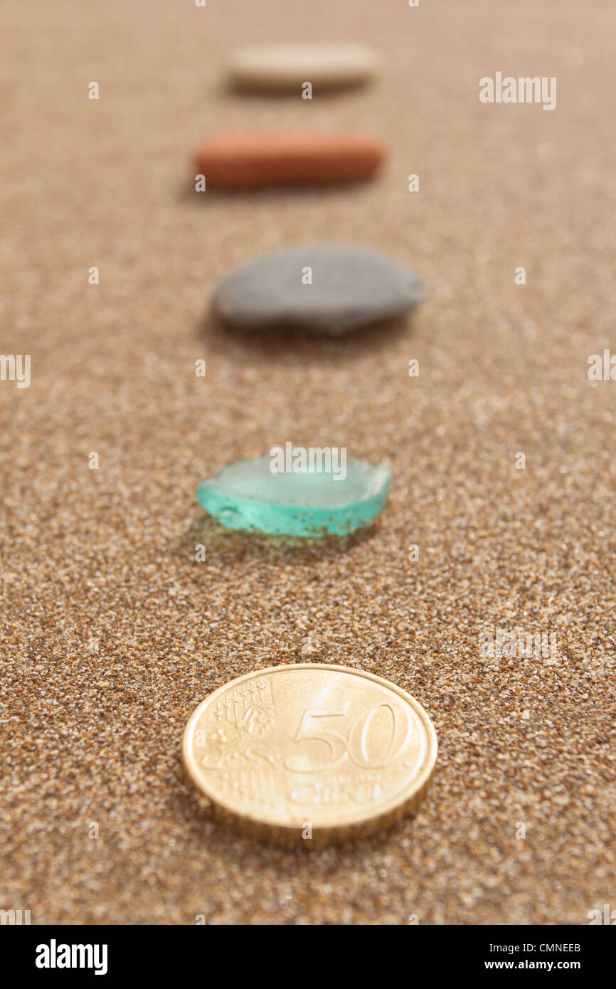Pebbles and a gold coin indicating the path to return on investment ...