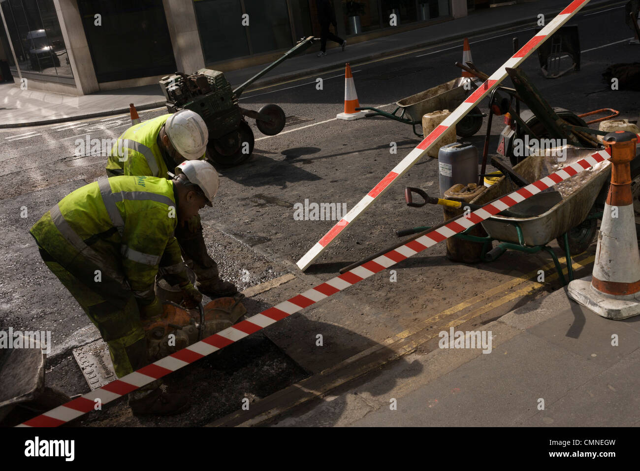Construction crew grind at the road surface surrounded by diagonals of ...