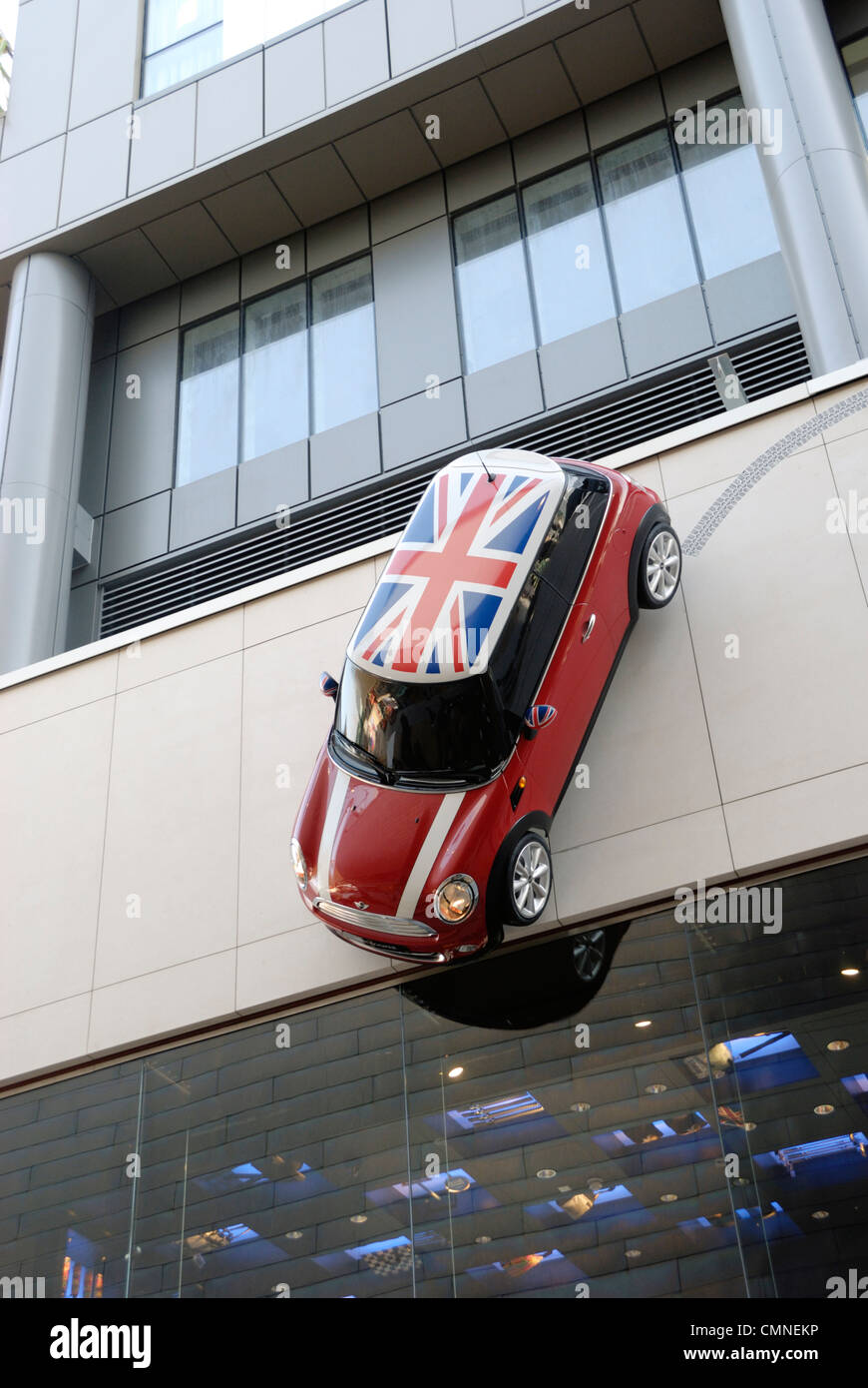 A Mini Cooper car defying gravity on the side of a building Stock Photo ...