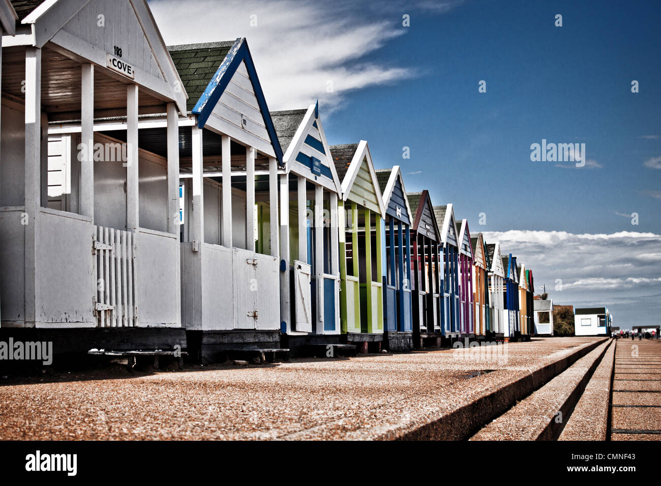 A line of colourful English beach huts on the East Anglian coast in ...