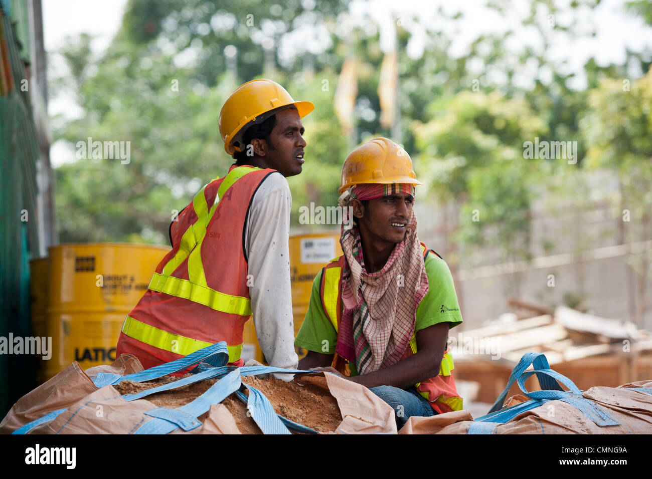 Migrant workers from South Asia take a break on the construction site ...