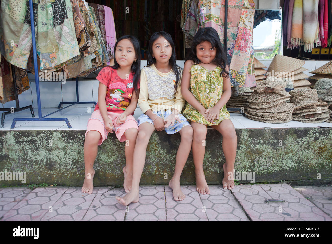 Three young Balinese girls sat outside a shop in Ubud, Bali Stock Photo ...