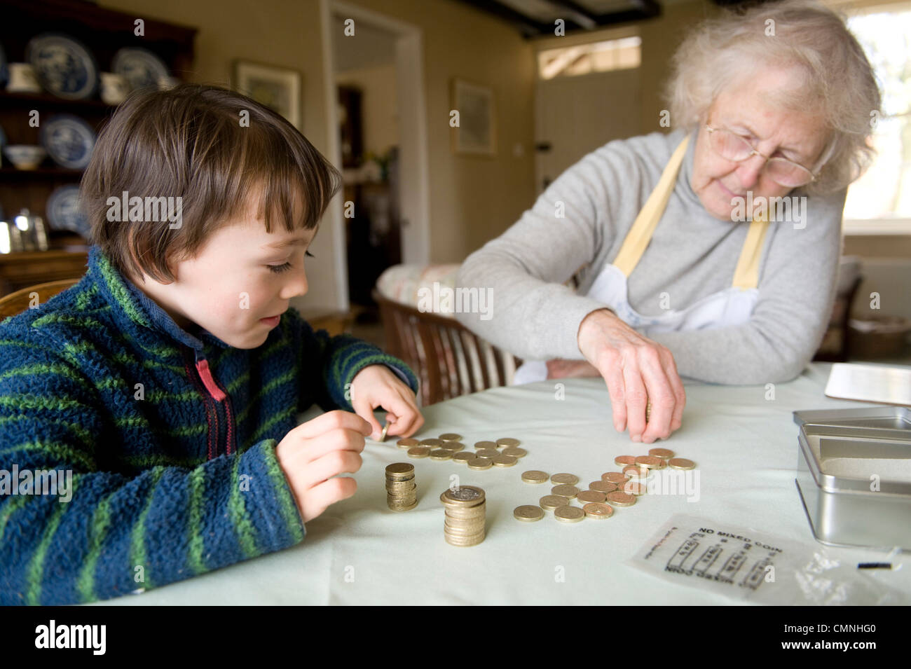 grandma and grandson counting coins at dining table Stock Photo - Alamy