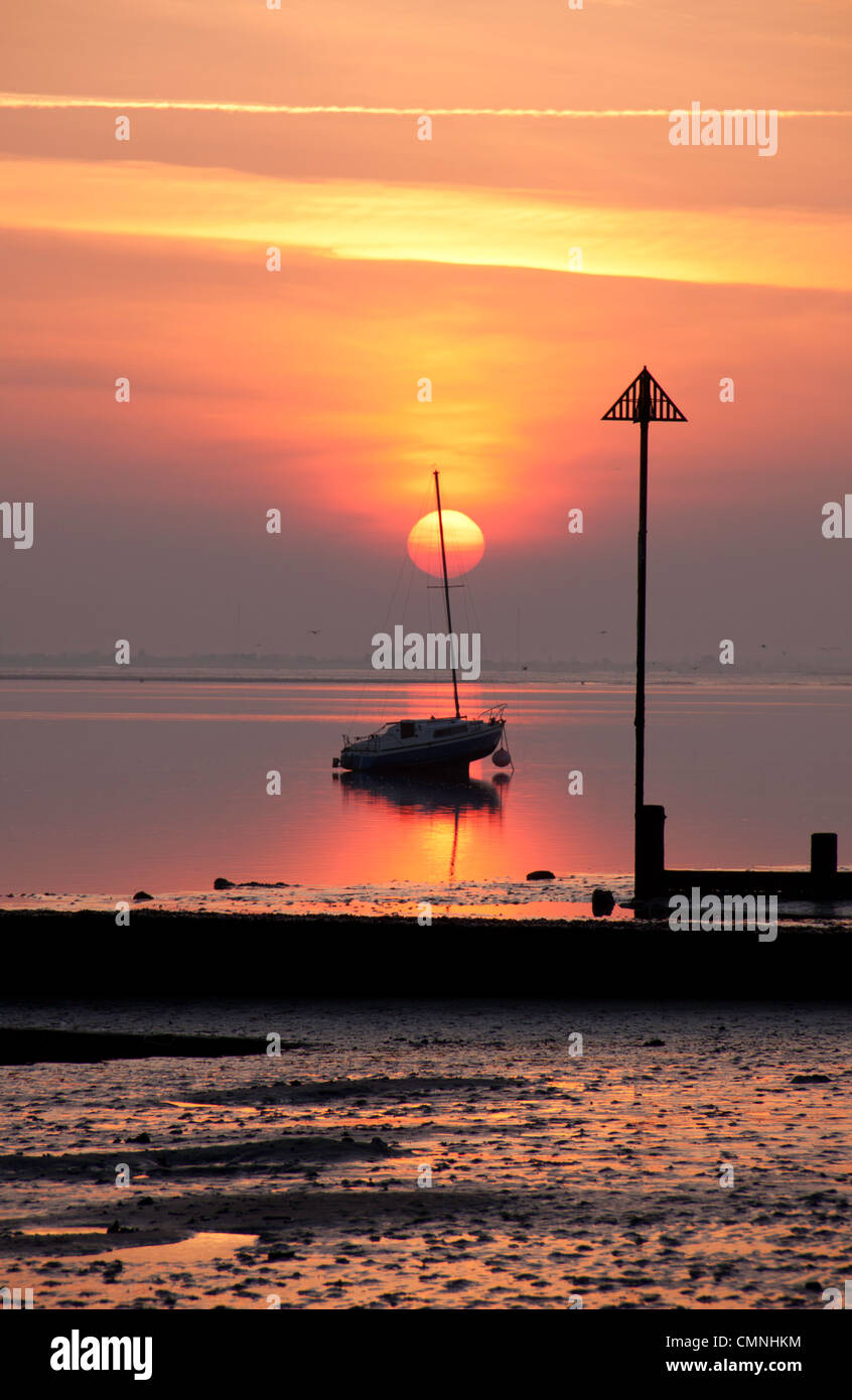 MAST CUTS THROUGH SETTING SUN ON A STILL EVENING Stock Photo - Alamy