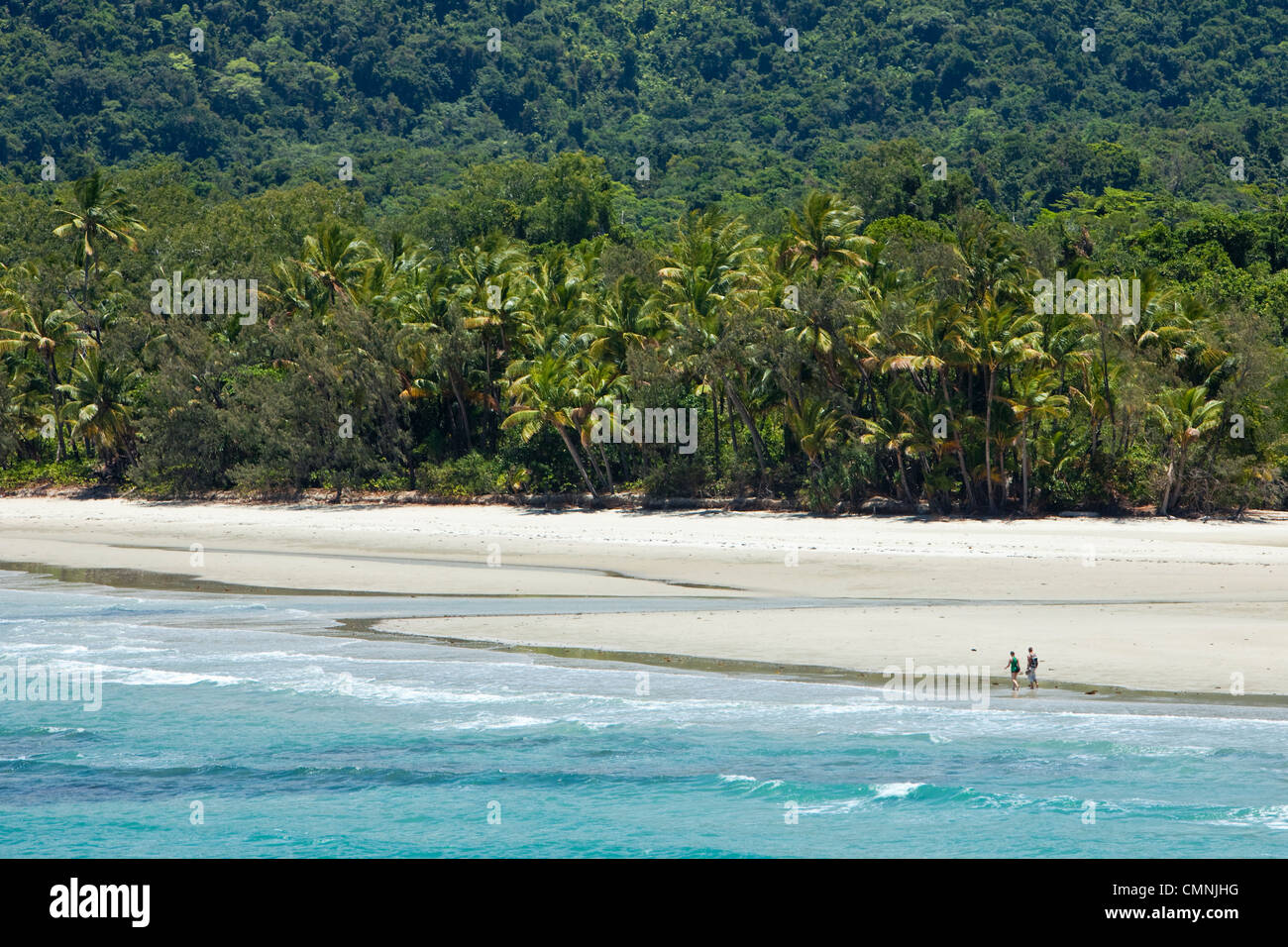 Couple walking along Myall Beach. Cape Tribulation, Daintree National ...