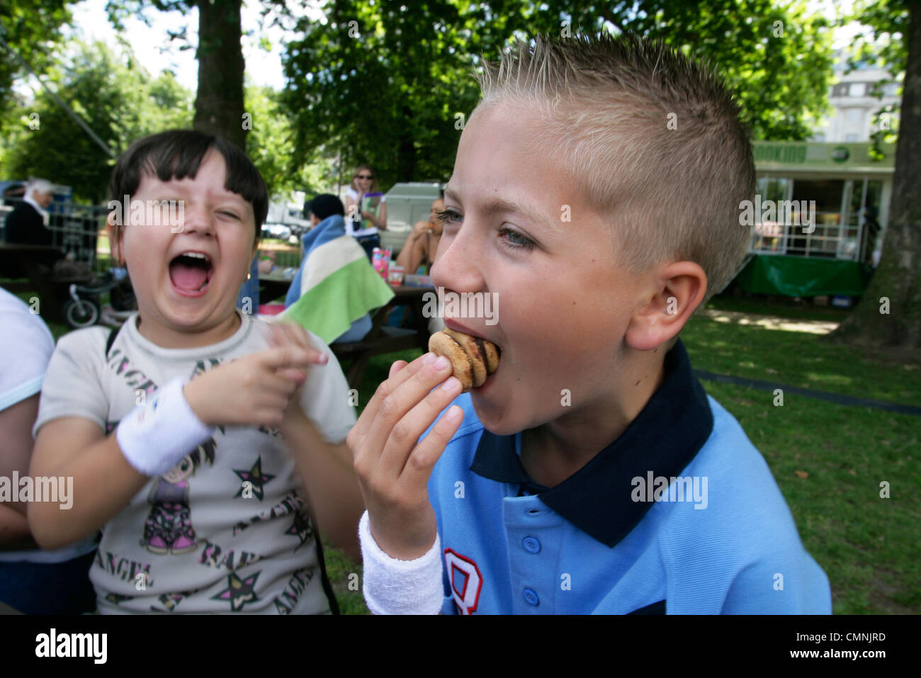 Boy eating a load of biscuits in Hyde Park London Stock Photo - Alamy