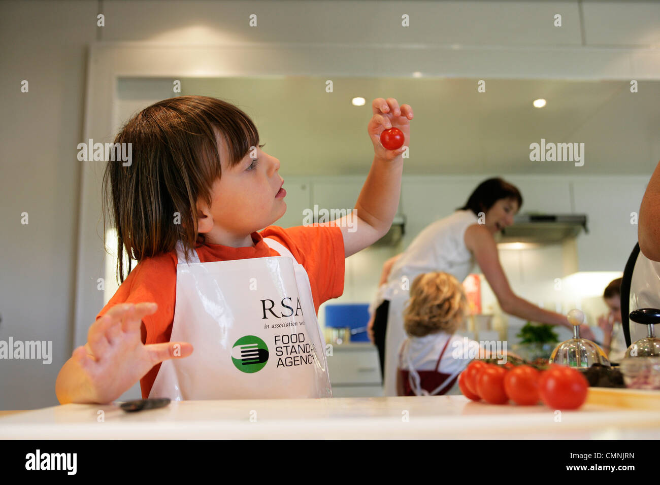 Child learning to cook fresh food at the Food Standard's "Eat well ...