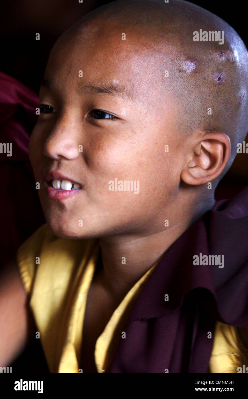 A young Tibetan Buddhist monk smiles during a ceremony at the monastery ...