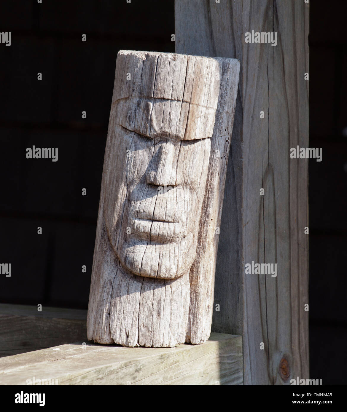 A carved head on a wood post Stock Photo - Alamy
