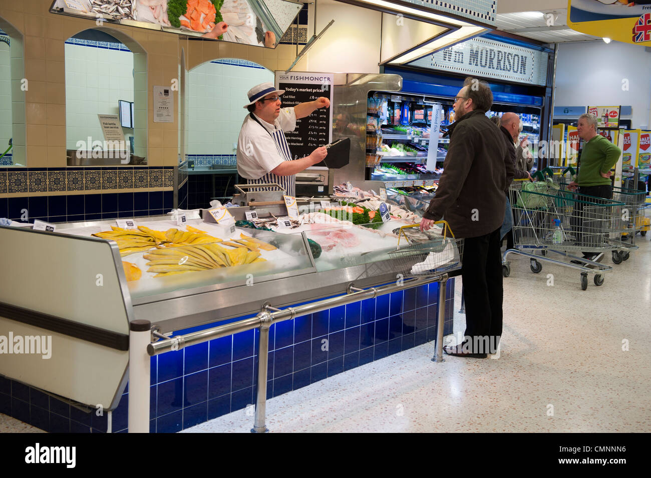 A fish monger serves a customer at Morrisons Supermarket, UK Stock ...