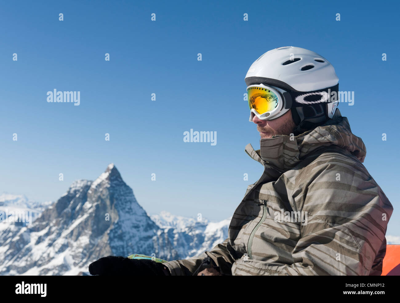 A snowboarder sitting on top of Breithorn, with Matterhorn in the ...