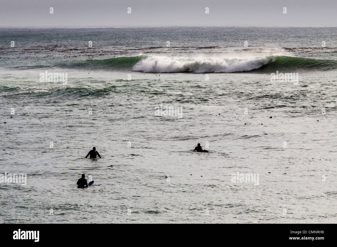Stormy weather and surfers waiting for a wave in Pacific Ocean at Point ...