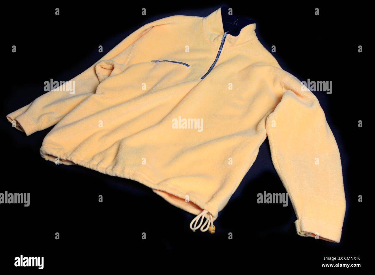 A yellow Fleece pullover jacket on a black background Stock Photo - Alamy