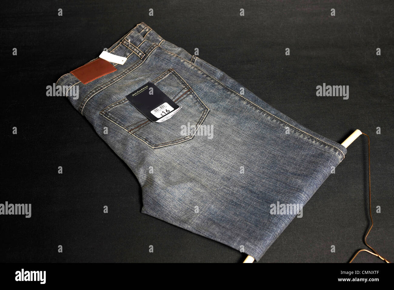 A pair of black stone washed jeans on a black background Stock Photo ...