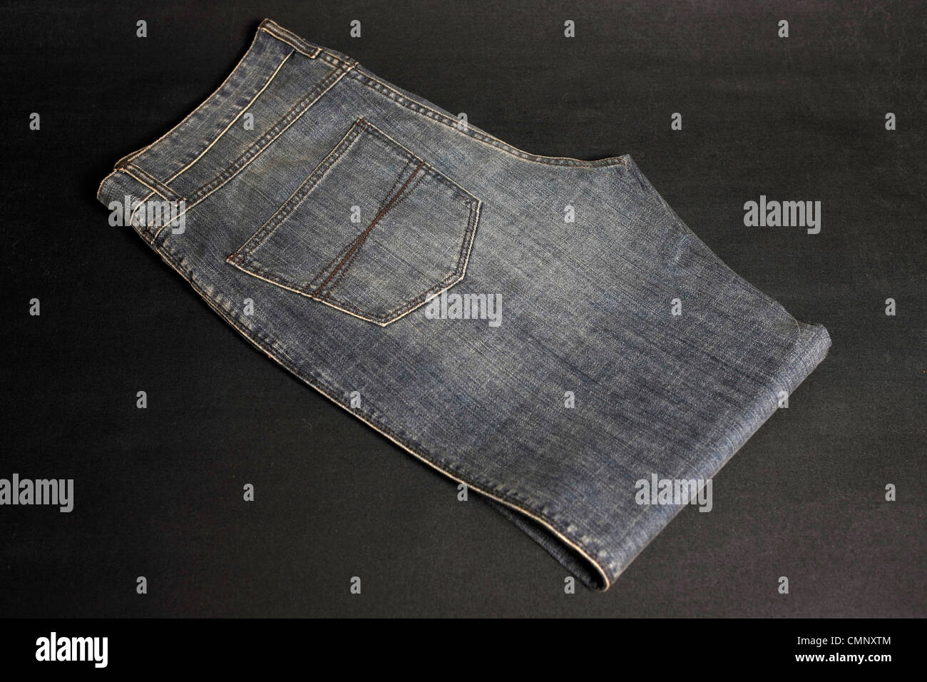 A pair of black stone washed jeans on a black background Stock Photo ...