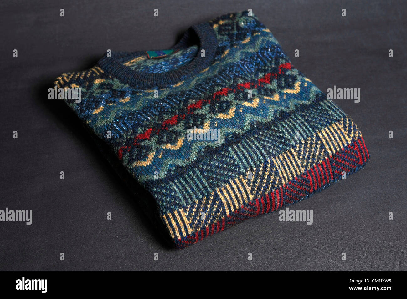 A folded blue patterned wool man's sweater on a black background Stock ...