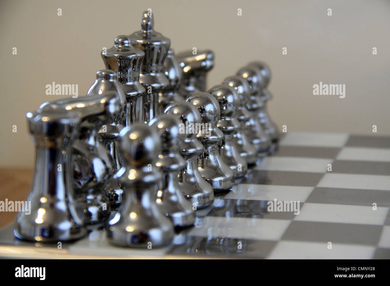 A chrome plated chess set, laid out ready to play on the chess board ...