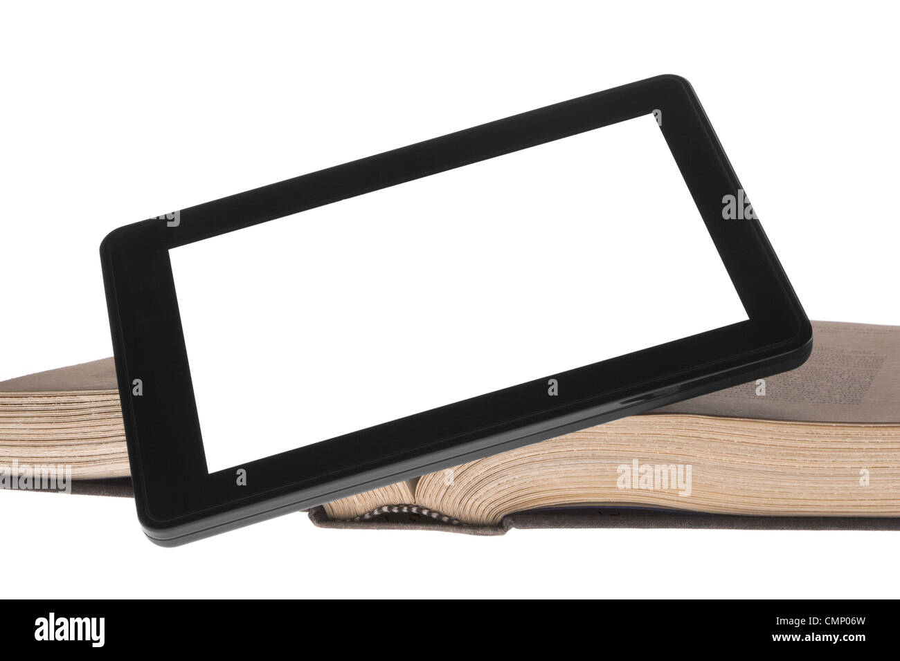 Digital tablet device, displaying white, leaning against old open book ...