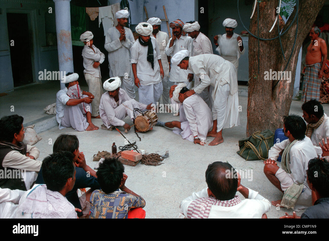 A traditional healer is exorcising a evil spirit from a hindu man ...