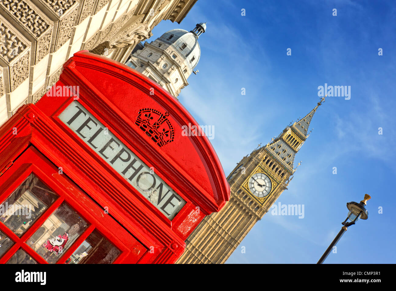 A bright red telephone box at an angle in front or Parliament in ...