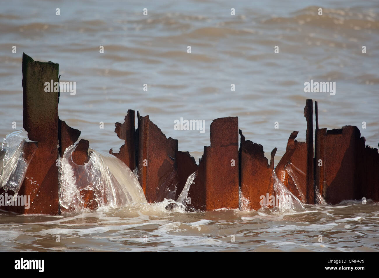 rusty metal groynes with sea pouring over Stock Photo - Alamy