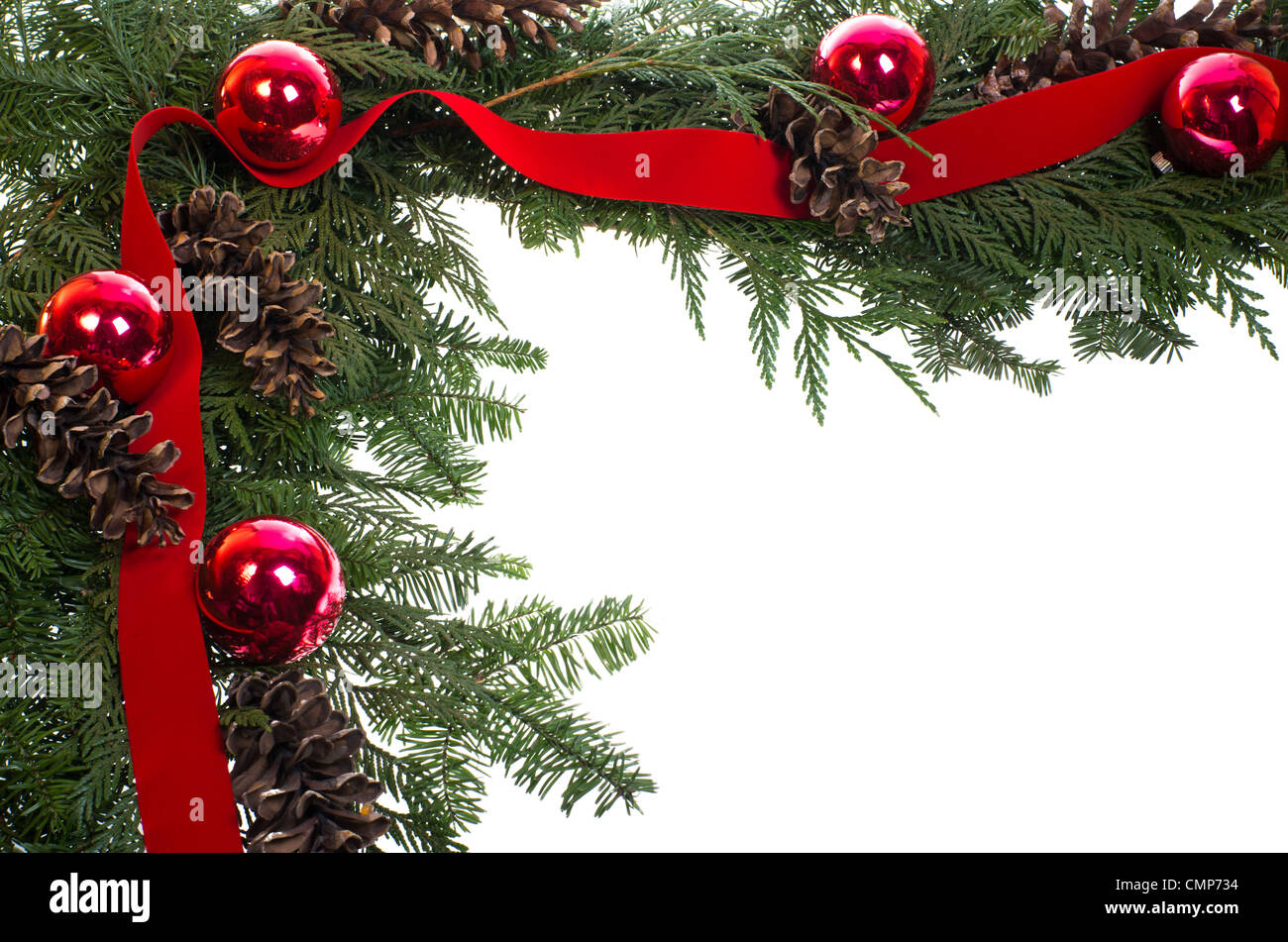 A decorative border of pine boughs ornaments cones and ribbon isolated ...