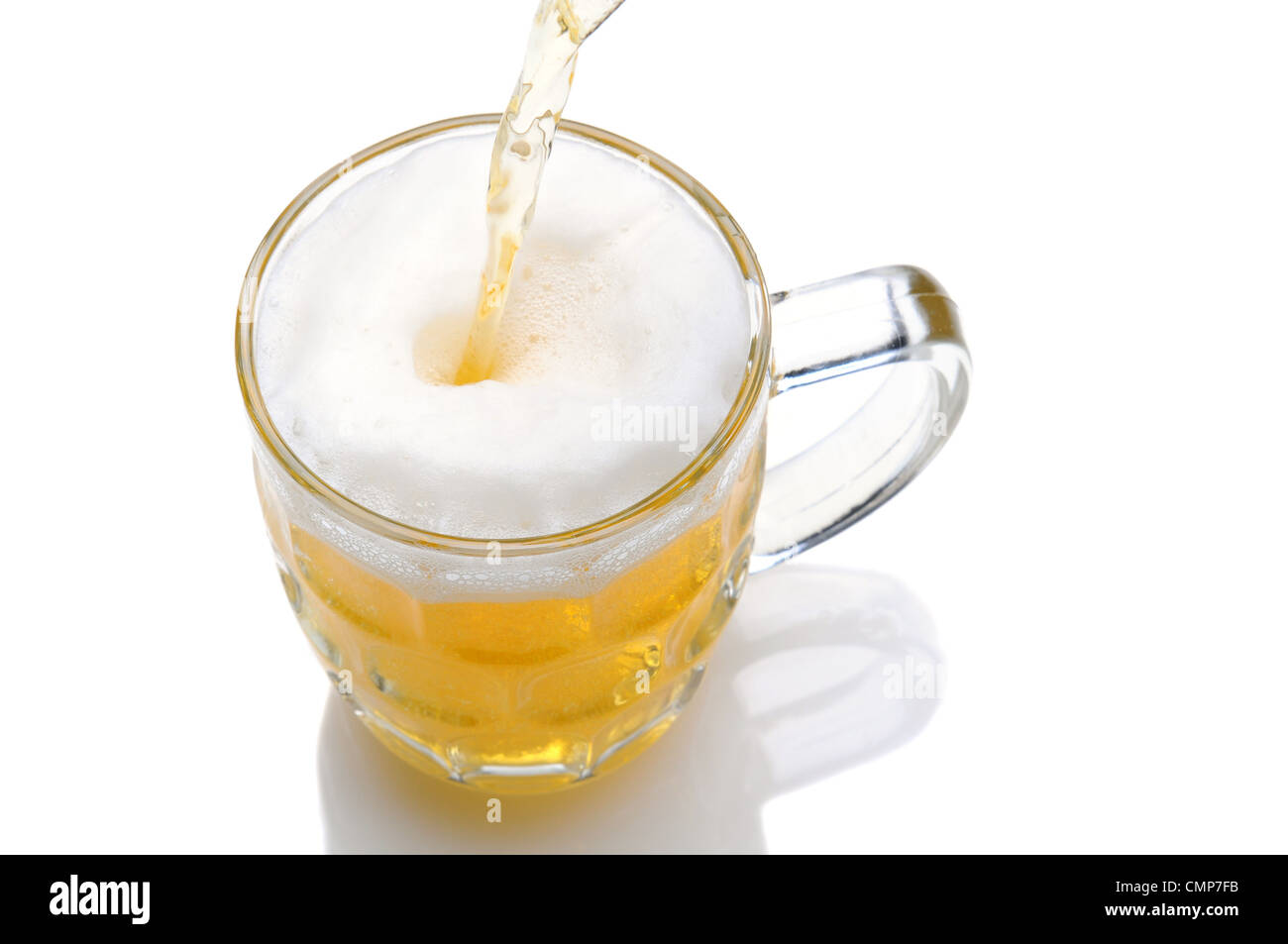 Cold beer pouring into a mug on a white background with reflection ...