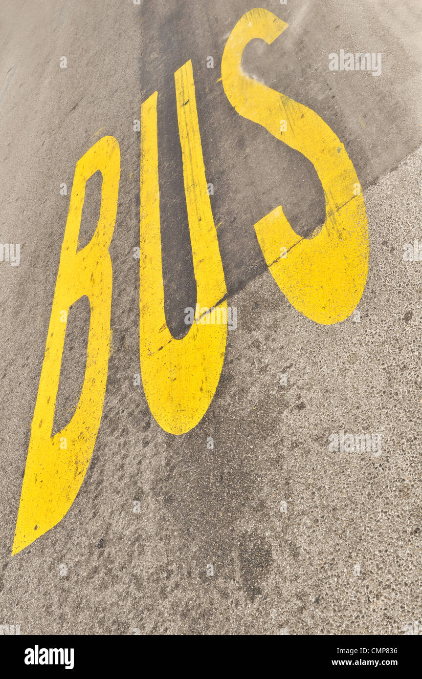 Yellow Bus sign painted on the asphalt Stock Photo - Alamy
