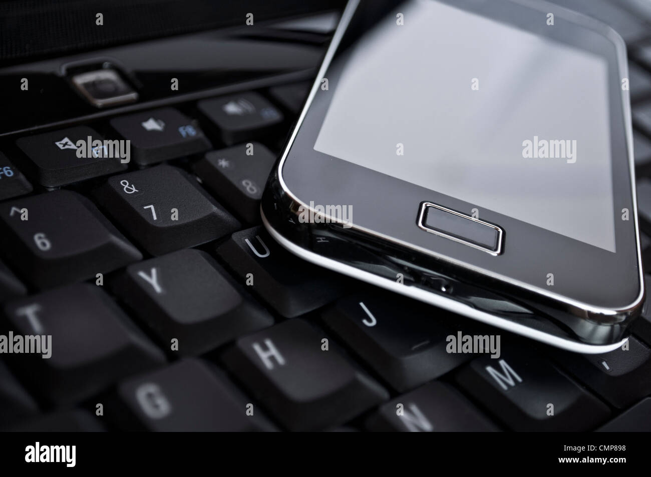 Cell phone on laptop keyboard - Business concept Stock Photo - Alamy