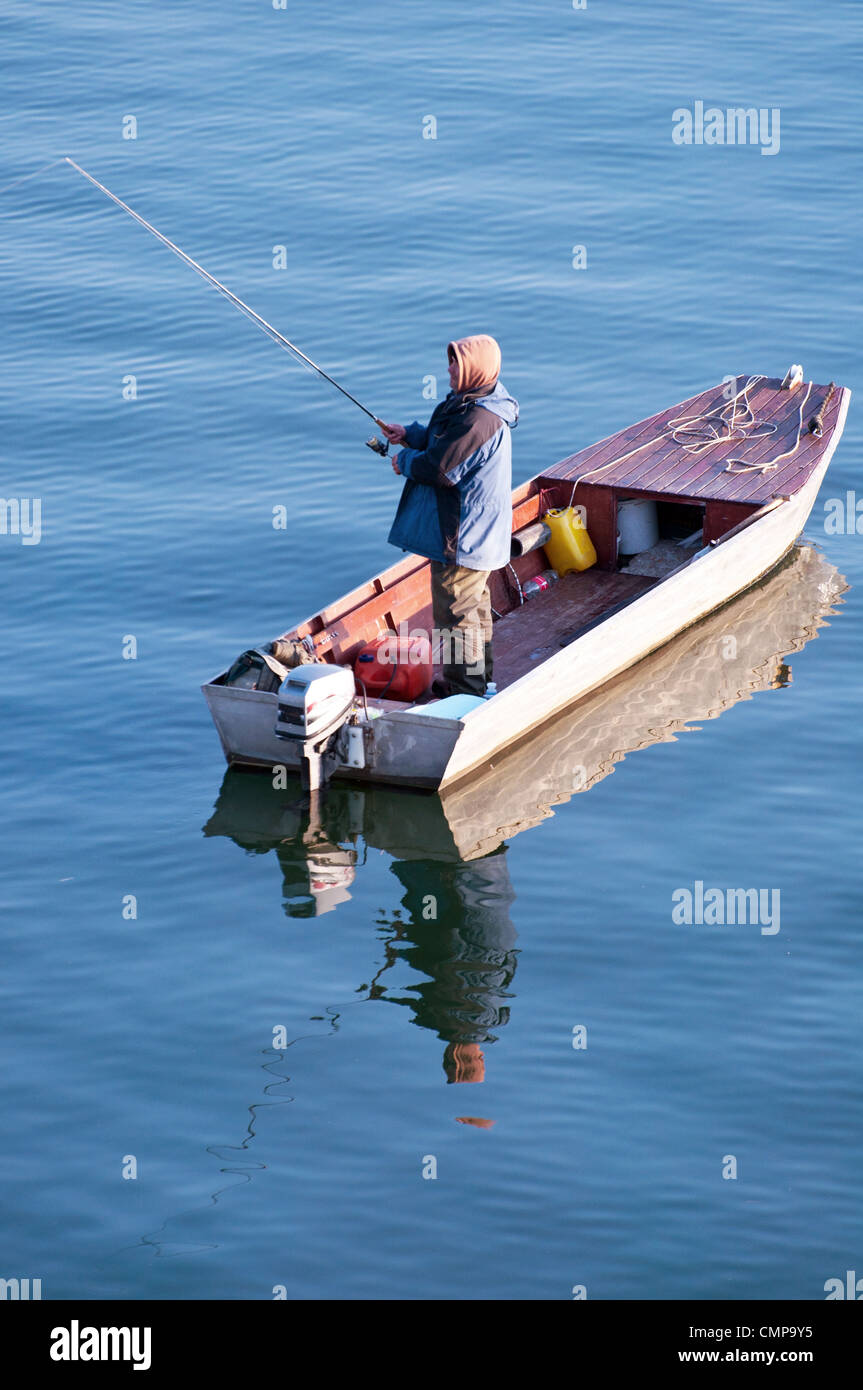 Fisherman in boat fishing Stock Photo - Alamy