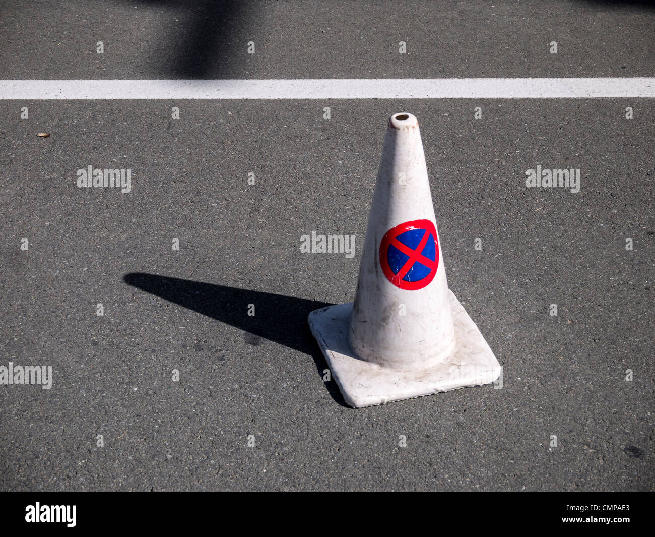 A white traffic cone with the red and blue "no parking / no stopping ...