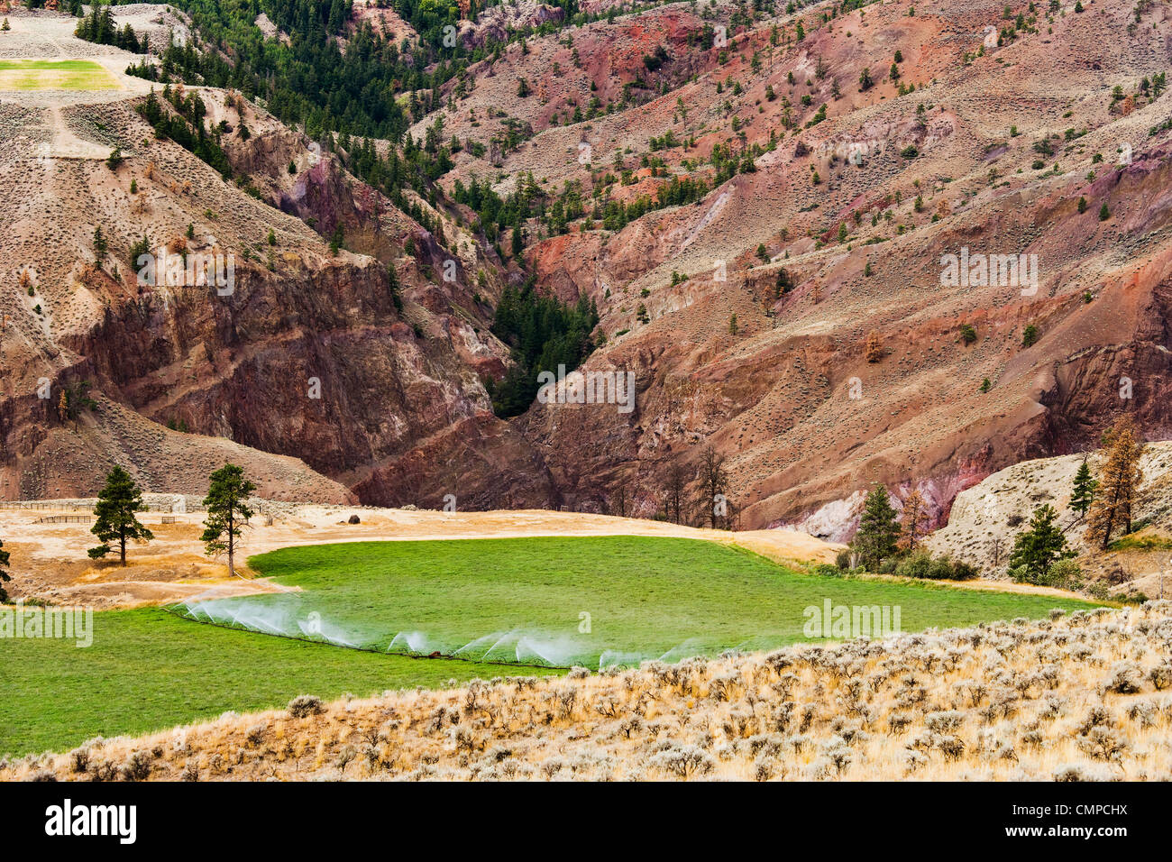 Irrigation system on field and red rock near Lillooet, British Columbia ...