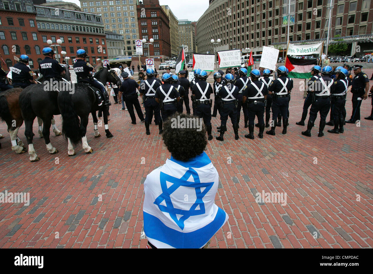 A man wrapped in an Israeli flag watches pro-Palestinian demonstrators ...