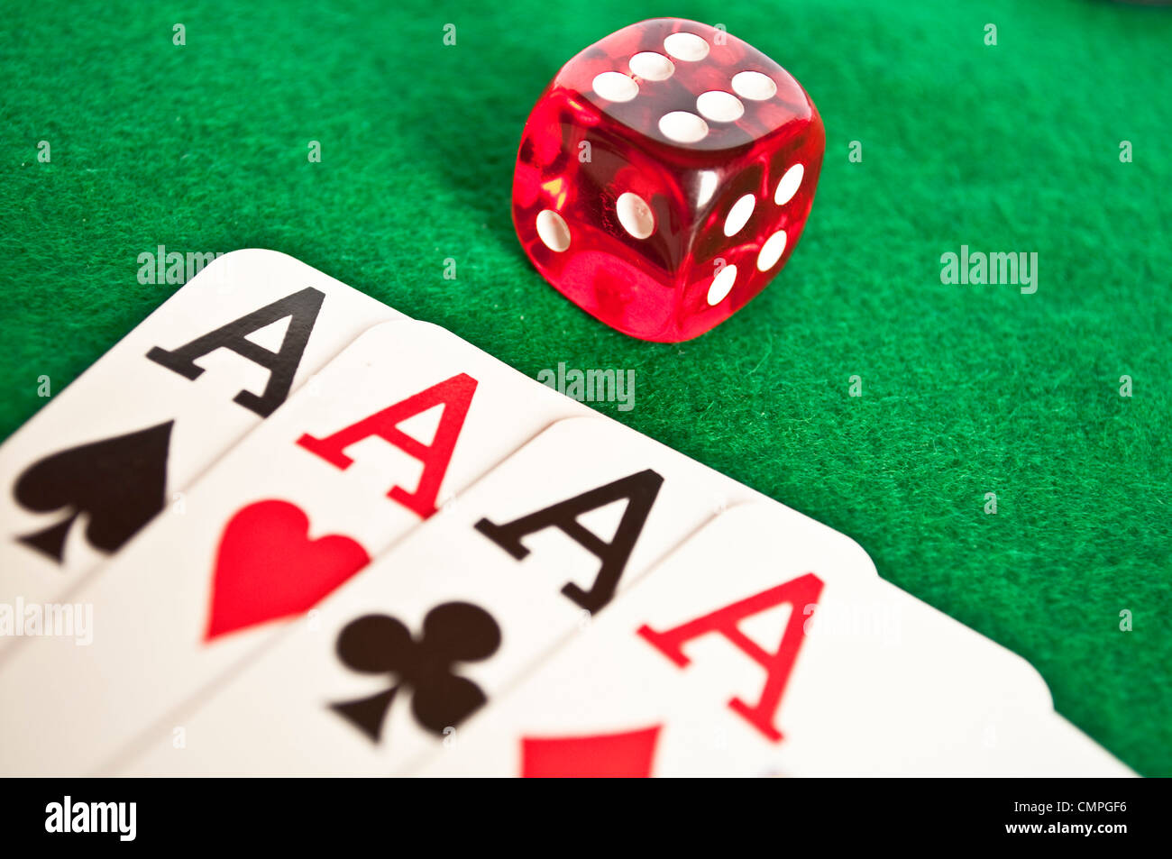 Four aces and red dice on green background Stock Photo - Alamy