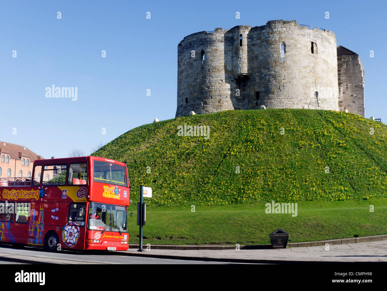 Cliffords Tower in York and a red tour bus Stock Photo - Alamy