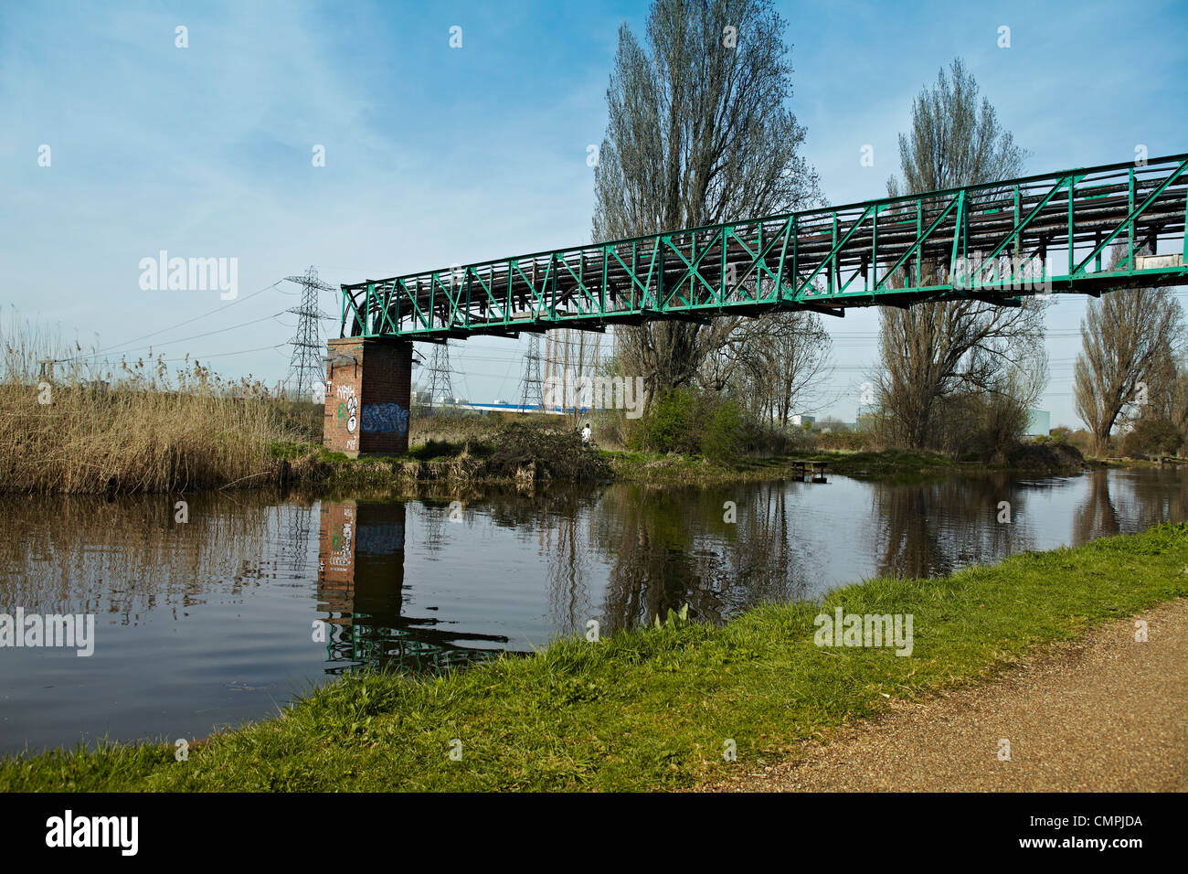 Canal scene with electricity pylons and pipe bridge on a sunny day ...