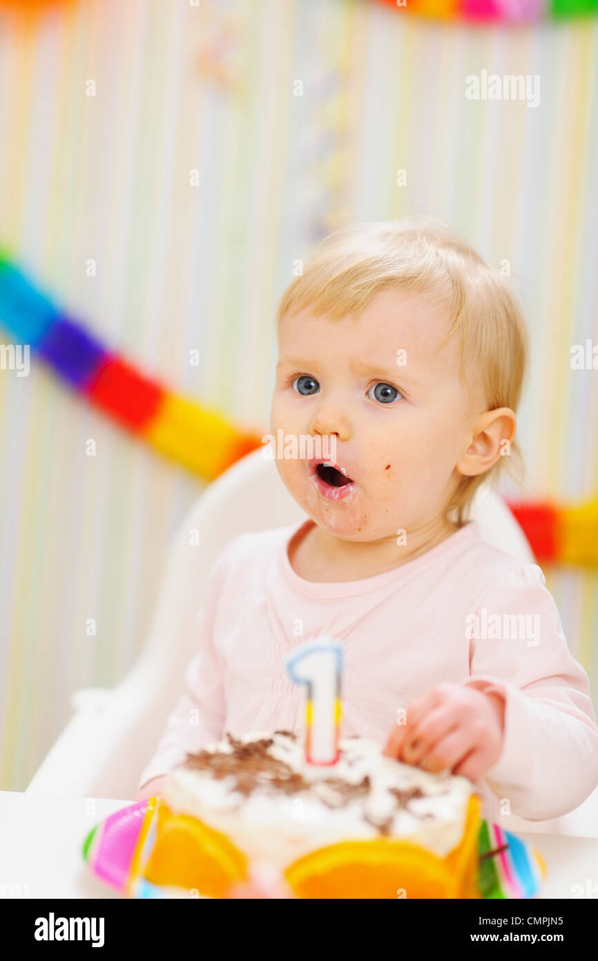 Surprised baby eating first birthday cake Stock Photo - Alamy