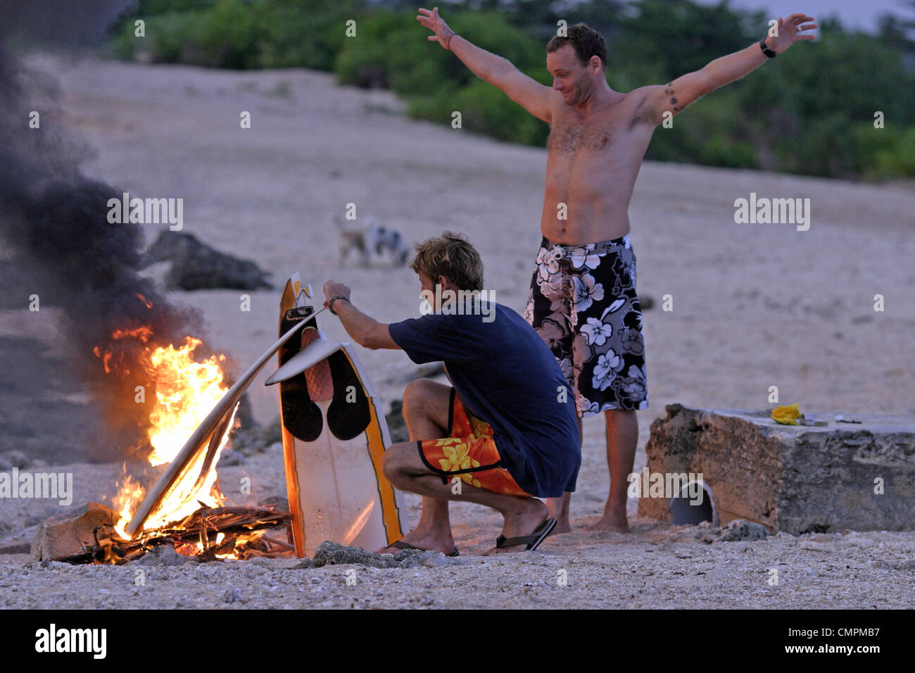 Surfers burn a broken surfboard on the beach and create toxic smoke ...