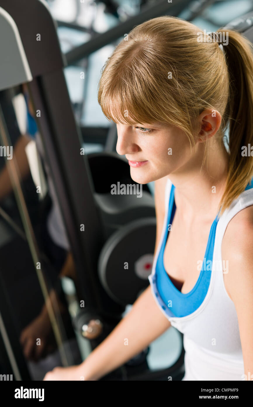 Fitness center young woman exercise on gym machine workout Stock Photo ...