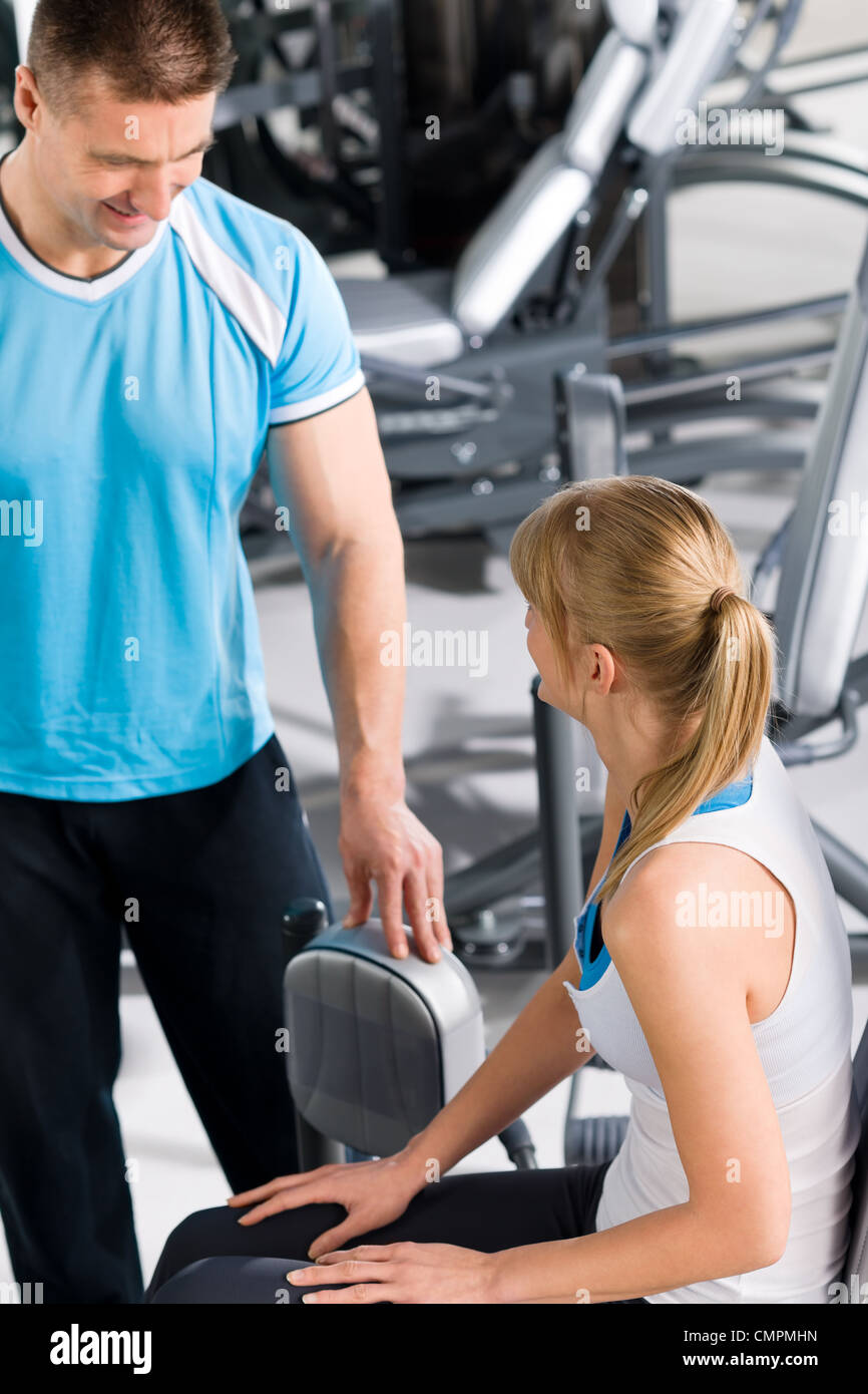 Young woman with personal trainer exercise legs at gym Stock Photo - Alamy