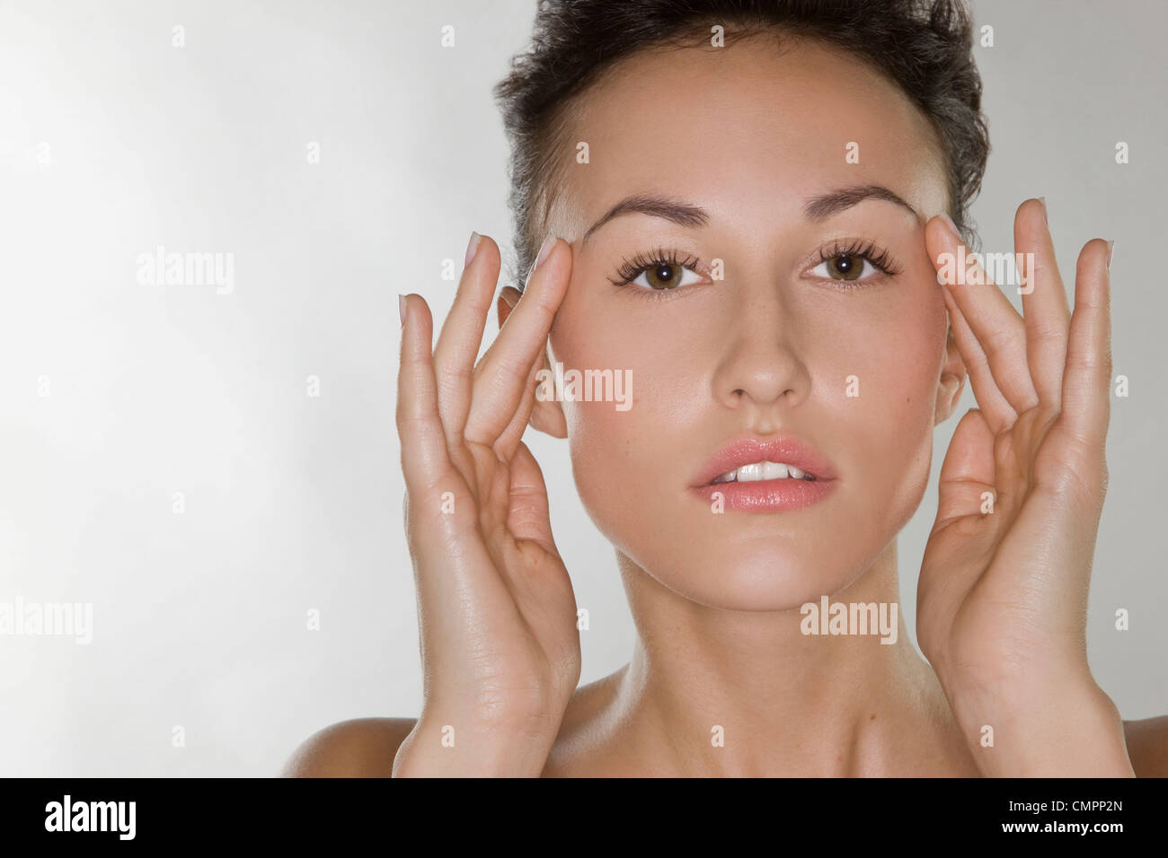 Woman looking at her face Stock Photo - Alamy