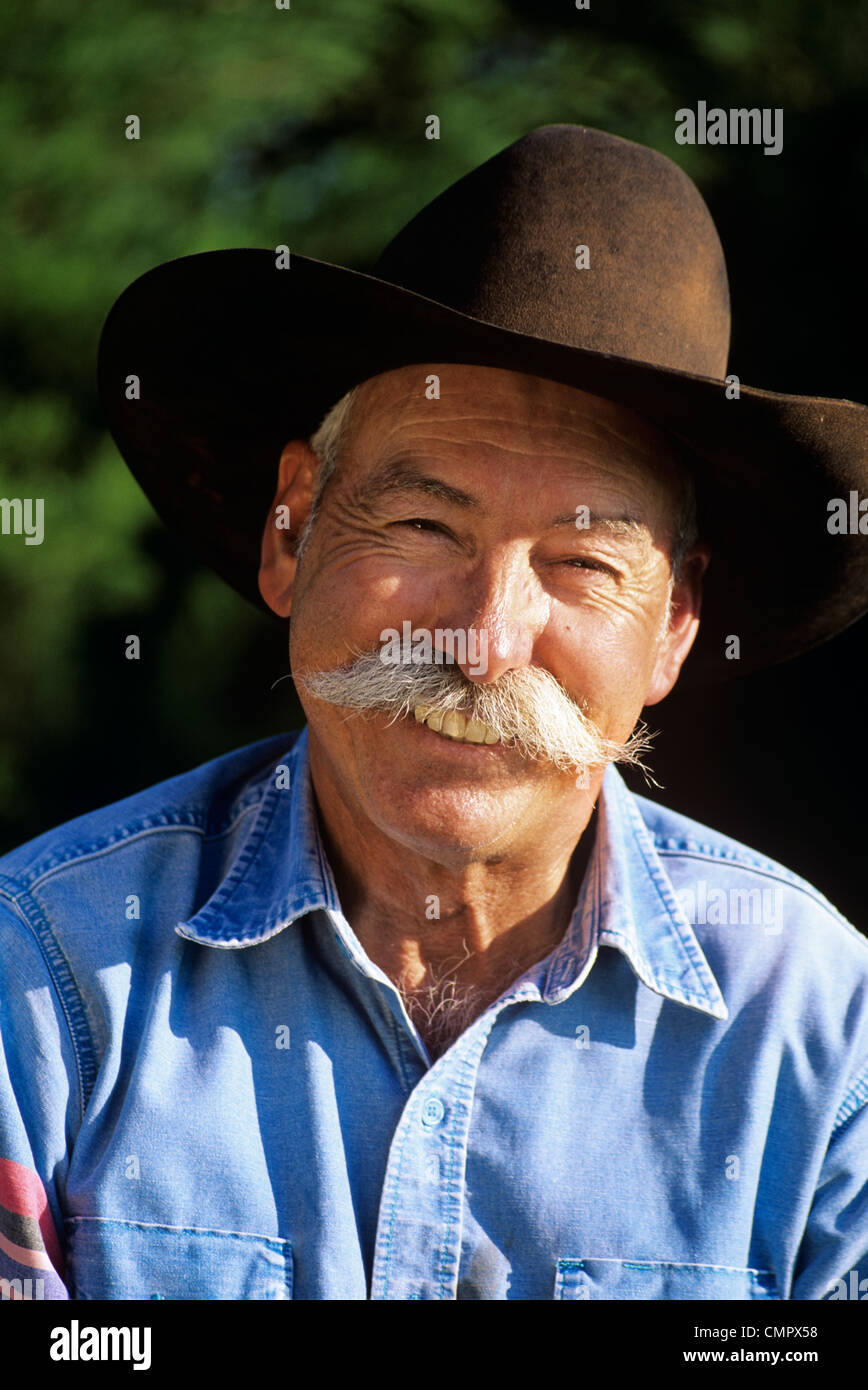1990s PORTRAIT OF SMILING COWBOY WITH GRAY MUSTACHE BLACK HAT BLUE ...